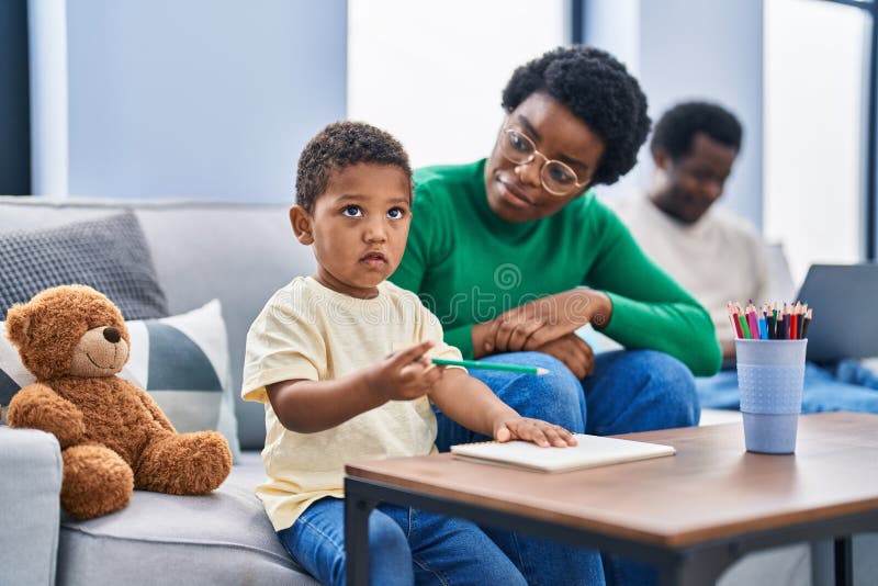 African American Family Drawing on Notebook and Using Laptop at Home ...