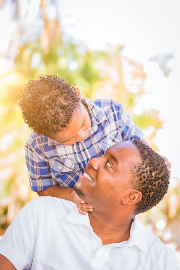 African American Father And Mixed Race Son Playing Outdoors Stock Image