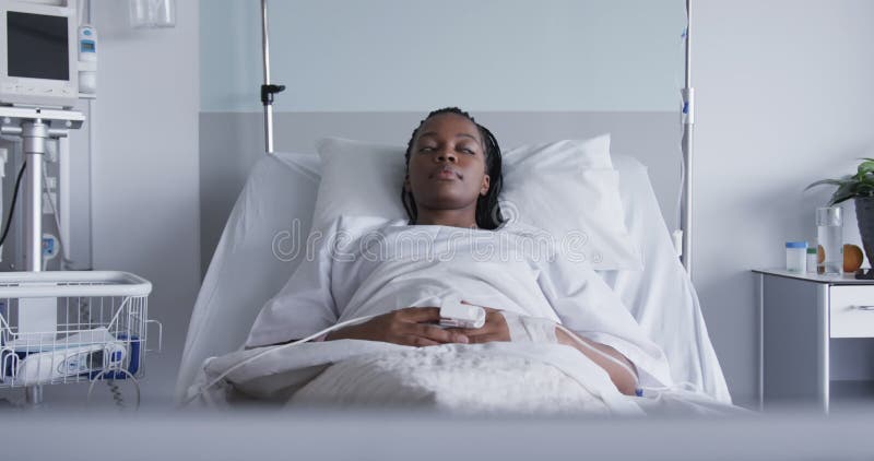 African American Female Patient Lying In Bed In Hospital Room Slow