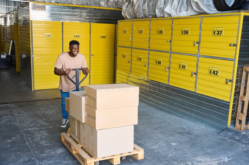 African American Guy is Pushing Cargo Cart Around a Warehouse Stock ...