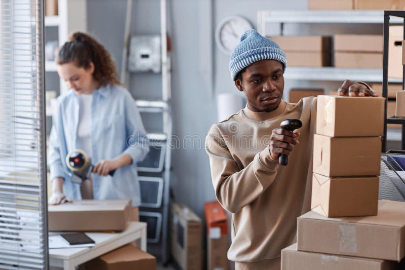 African American Male Worker of Storage Room Scanning Codes on Boxes ...