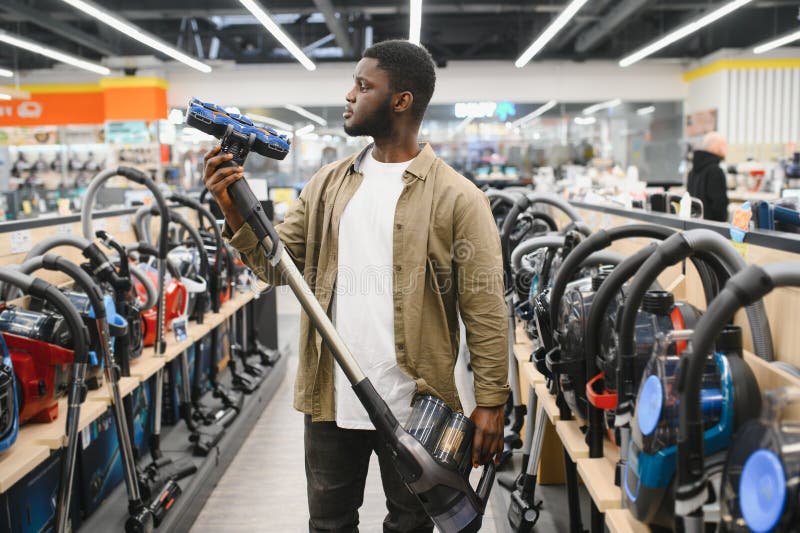 An African American Man Chooses a New Model of Vacuum Cleaner in an ...