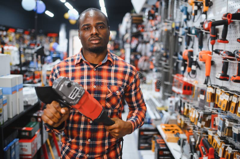 A African American Man Chooses a Power Tool in a Hardware Store Stock ...