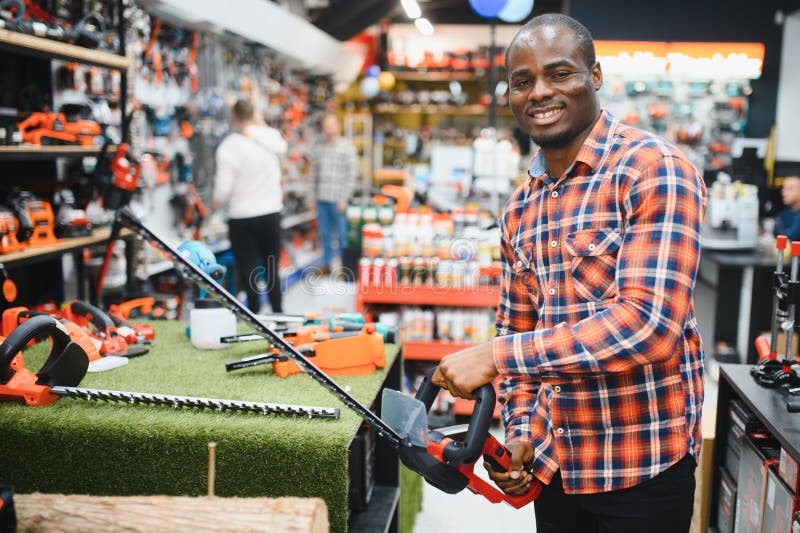 A African American Man Chooses a Power Tool in a Hardware Store Stock ...