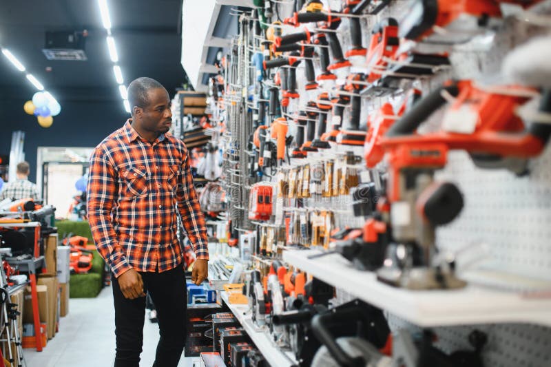 A African American Man Chooses a Power Tool in a Hardware Store Stock ...