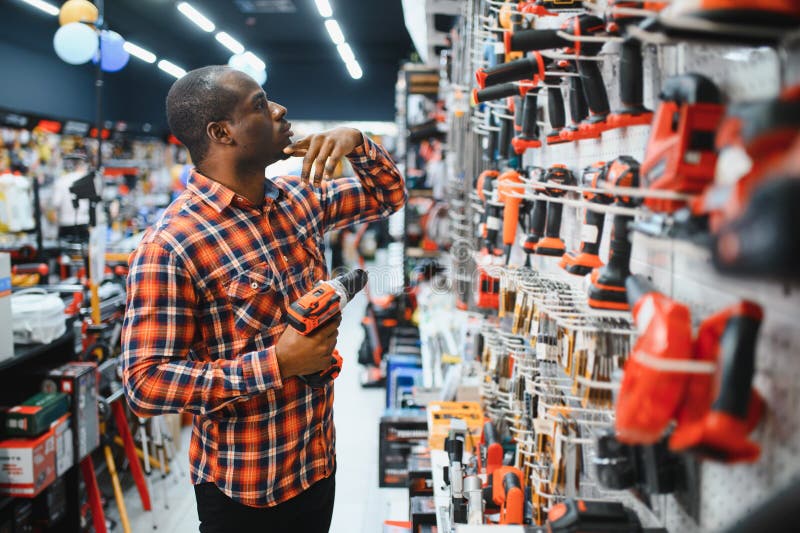 A African American Man Chooses a Power Tool in a Hardware Store Stock ...