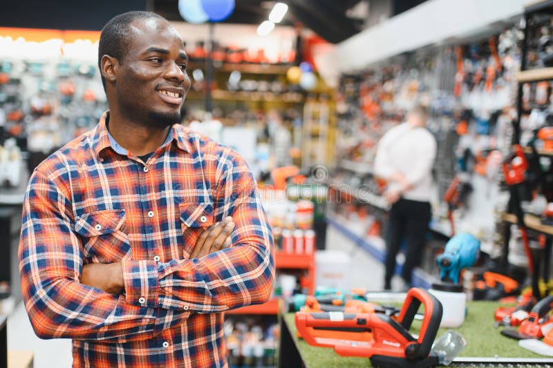 A African American Man Chooses a Power Tool in a Hardware Store Stock ...