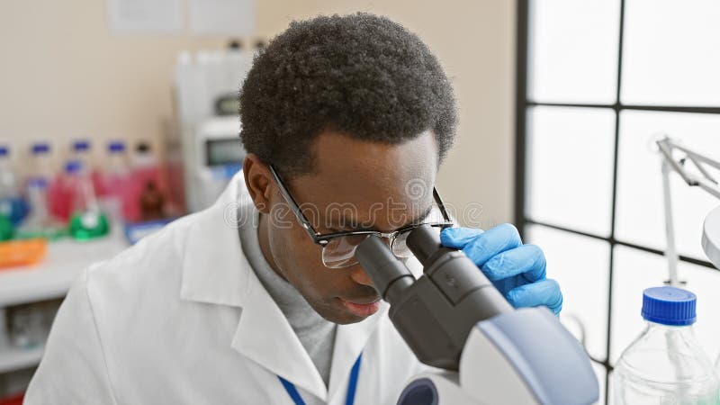 African American Man Conducting Research Using a Microscope in a ...