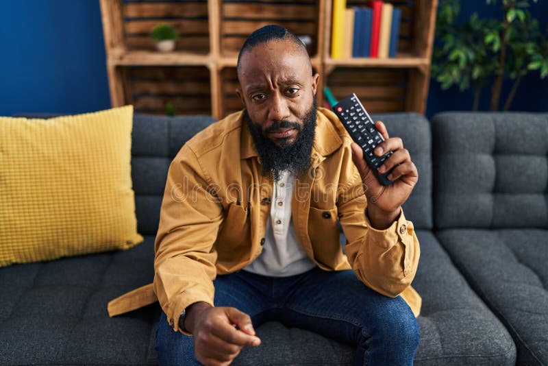 African American Man Holding Television Remote Control Thinking ...