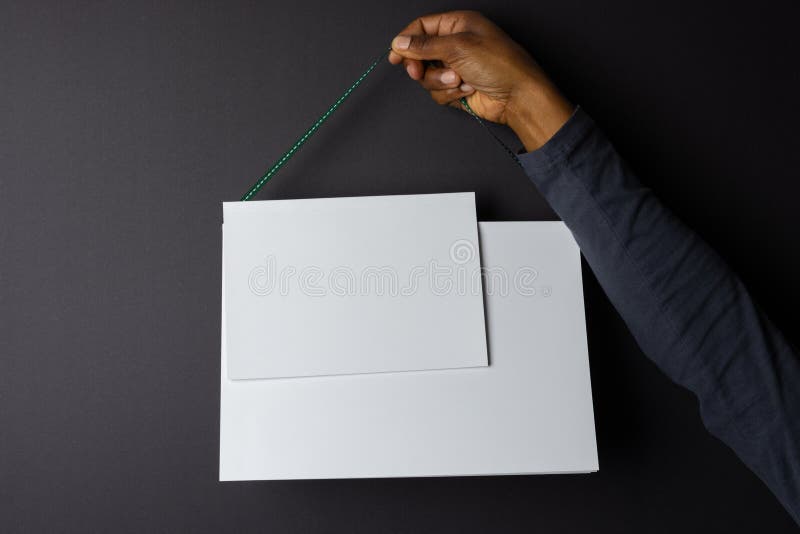 African American Man Measuring an Envelope on a Dark Surface with Copy ...