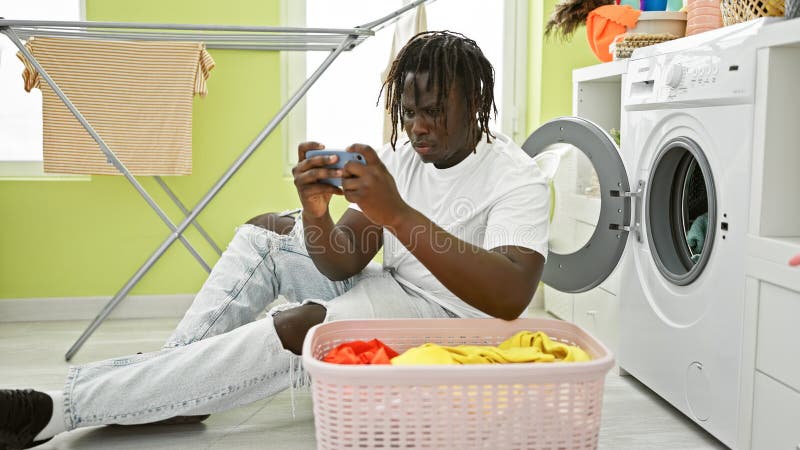 African American Man Playing Video Game at Laundry Room Stock Image ...