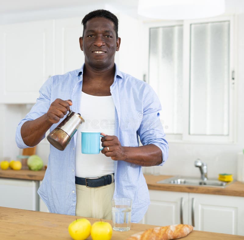 African American Man Pouring Coffee from Coffee Pot for Breakfast in ...