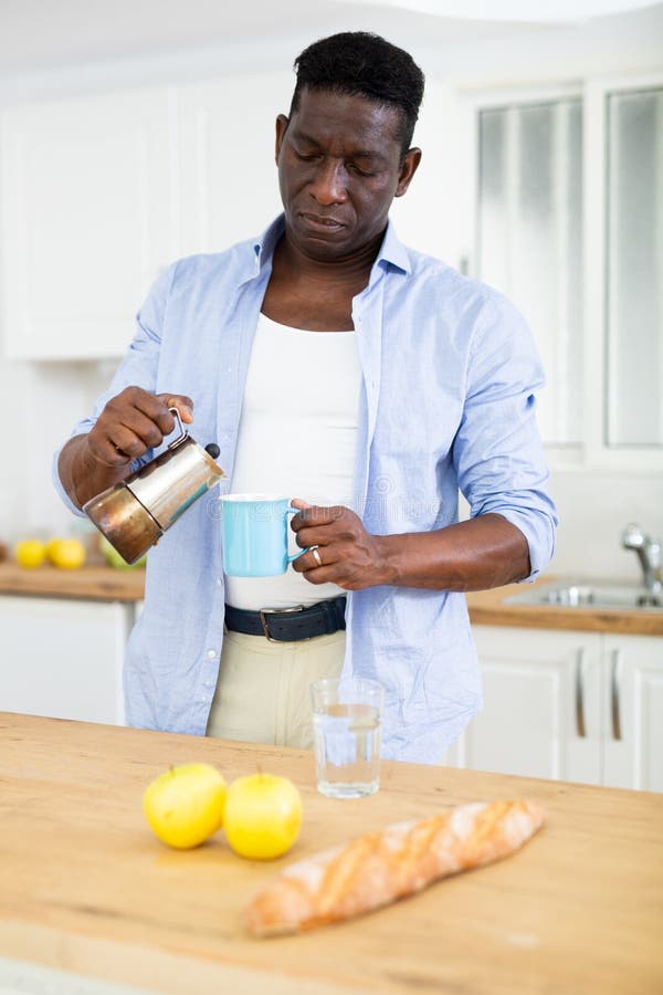 African American Man Pouring Coffee from Coffee Pot for Breakfast in ...