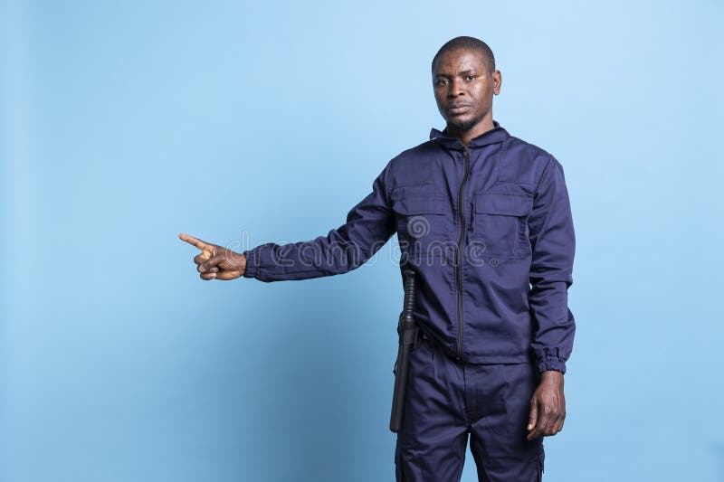 African American Man in Security Agent Uniform Points To the Left or ...