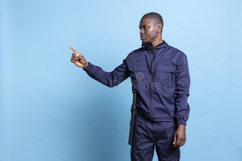 African American Man in Security Guard Uniform Pointing To the Left ...