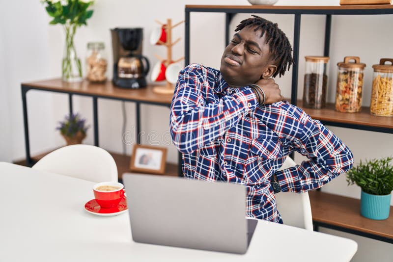 African American Man Stressed Using Laptop Sitting on Table at Home ...