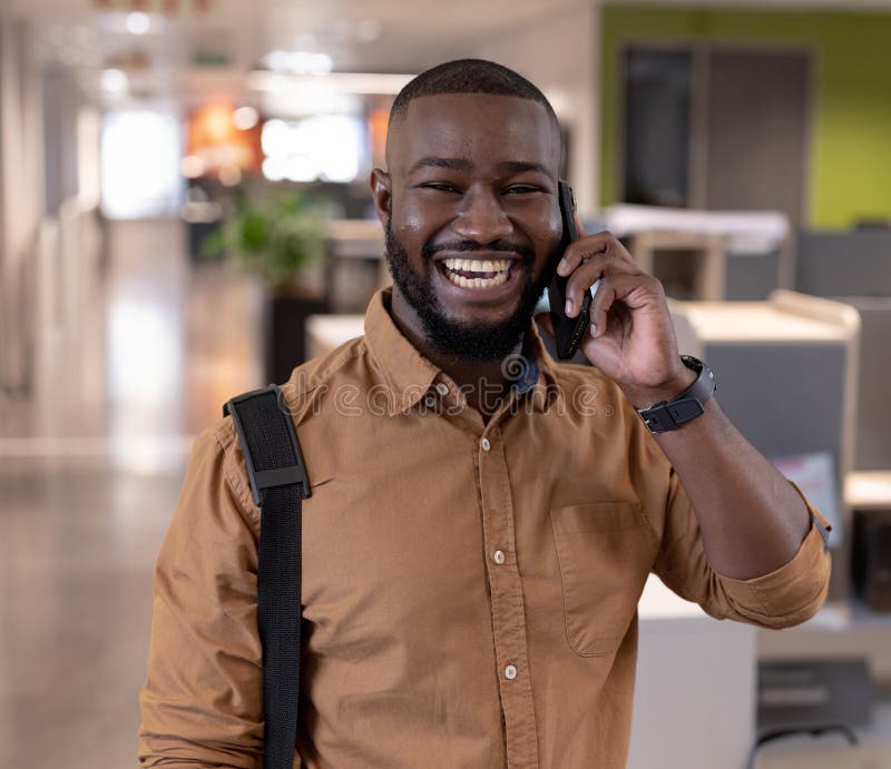 African American Man Talking on Smartphone in Modern Office, with ...
