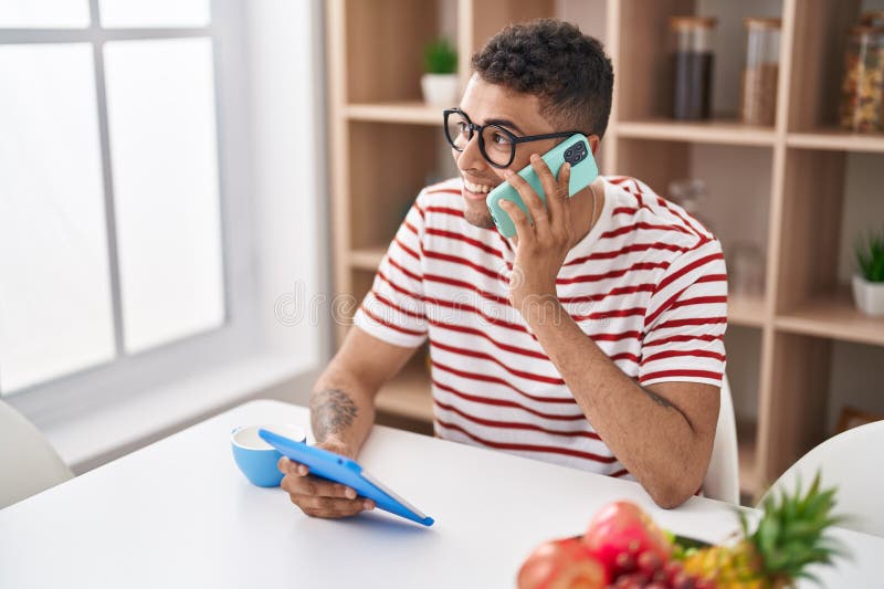 African American Man Talking on the Smartphone Using Touchpad at Home ...