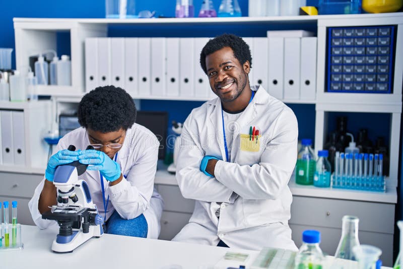 African American Man and Woman Scientists Using Microscope at ...