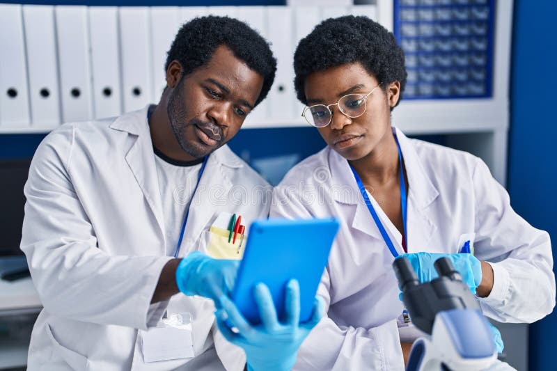 African American Man and Woman Scientists Using Touchpad Working at ...