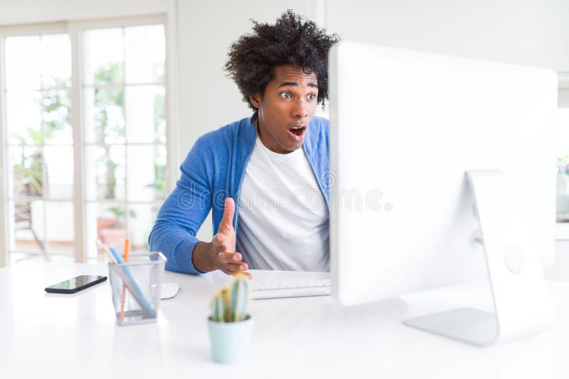 African American Man Working Using Computer Scared in Shock with a ...