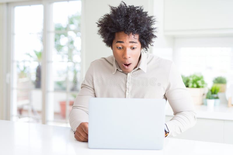 African American Man Working Using Laptop Scared in Shock with a ...