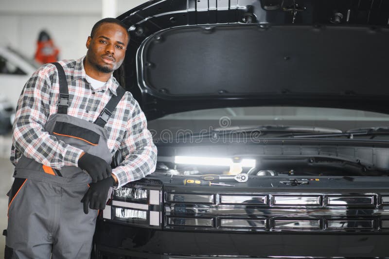An African-American Mechanic Confidently Posing with Tools in Hand in ...