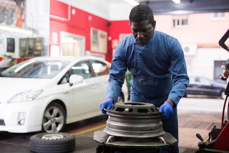 African American Mechanic Fixes Car Rims in Car Service Stock Photo ...