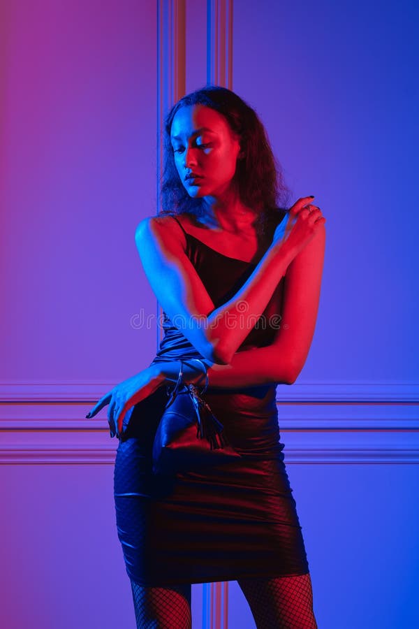 African American Model Posing with Triangular Hand Bag Under Neon ...