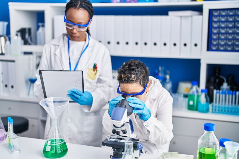 African American Mother and Son Scientists Using Microscope Laboratory ...