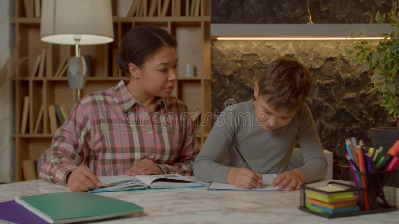African American Mother with Tutorial Helping School Age Son To Do ...