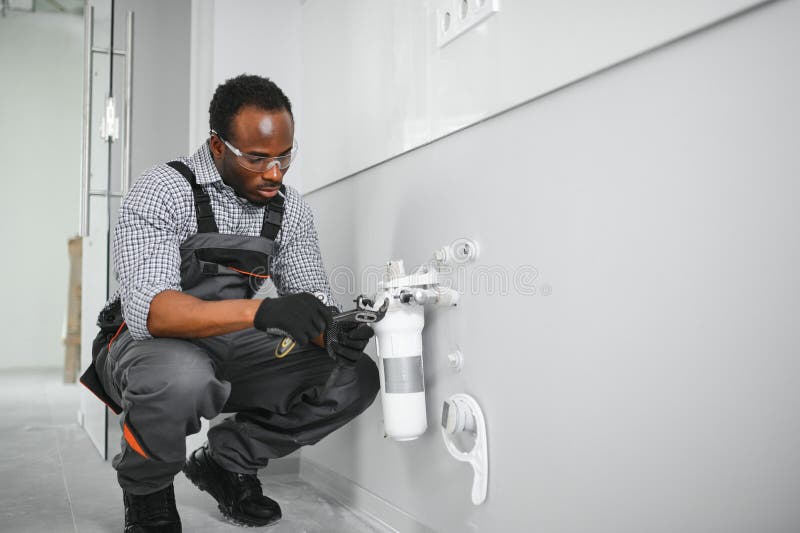 African American Plumber Change the Water Filter. Stock Photo - Image ...