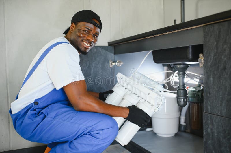 African American Plumber Change the Water Filter. Stock Image - Image ...