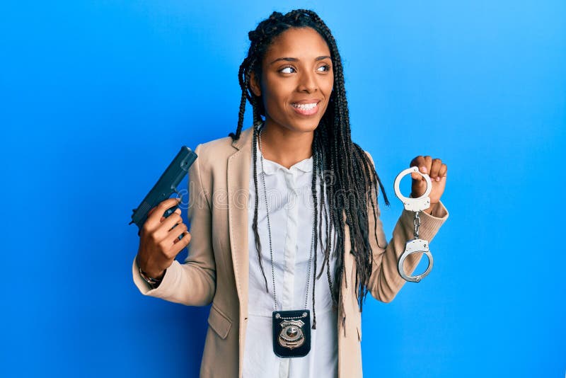 African American Police Woman Holding Gun And Handcuffs Smiling Looking
