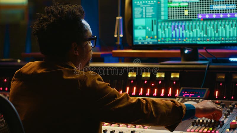 African American Producer Working at Mixing Panel in Recording Studio ...