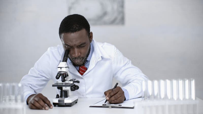African American Scientist Looking through Microscope Stock Photo ...
