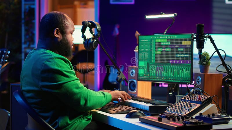 African American Sound Engineer Using Midi Controller Notes To Add ...