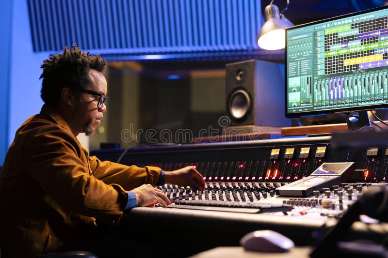 African American Sound Engineer Works on Mixing Console with Sliders ...