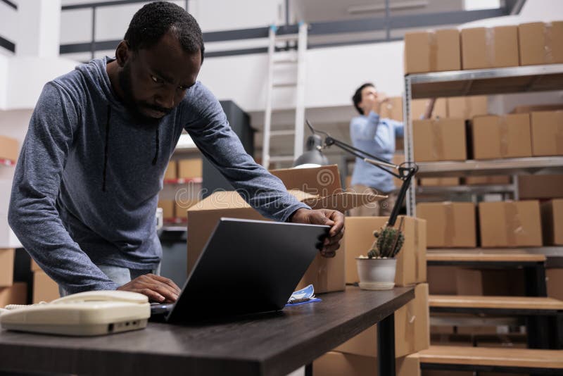 African American Supervisor Looking at Cargo Stock on Laptop Computer ...