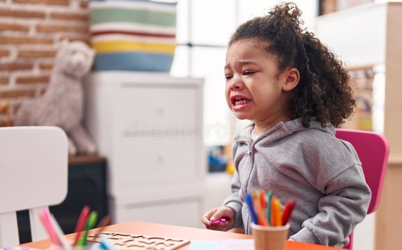 African American Toddler Sitting on Table Crying at Kindergarten Stock ...