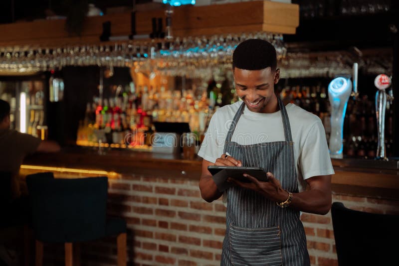 African American Waiter Working In Restaurant On Digital Tablet Stock