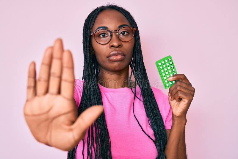 African American Woman With Braids Holding Birth Control Pills With