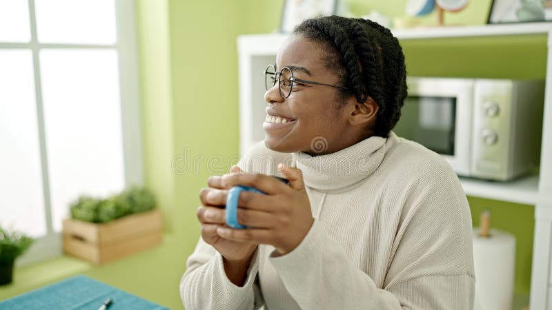 African American Woman Drinking Coffee Sitting On Table At Dinning Room