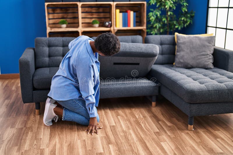 African American Woman Looking for Under Sofa at Home Stock Image ...