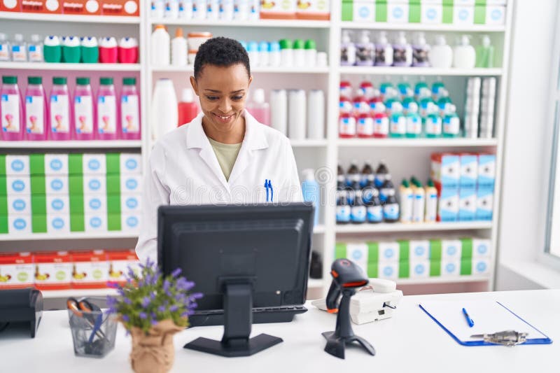 African American Woman Pharmacist Smiling Confident Using Computer at ...