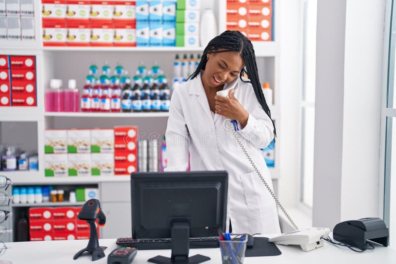 African American Woman Pharmacist Talking on Telephone Using Computer ...