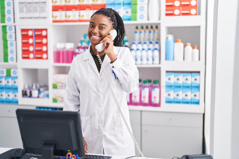 African American Woman Pharmacist Talking on Telephone Using Computer ...