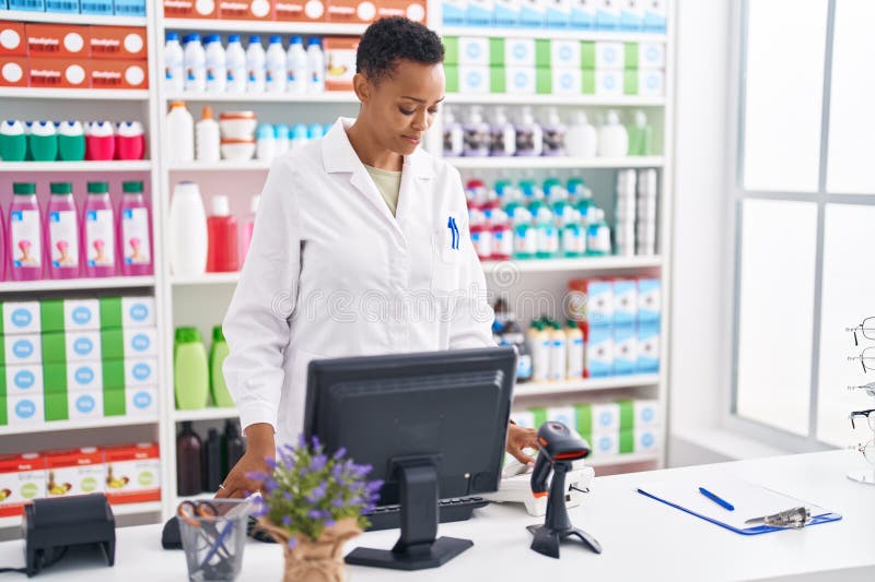 African American Woman Pharmacist Using Computer at Pharmacy Stock ...