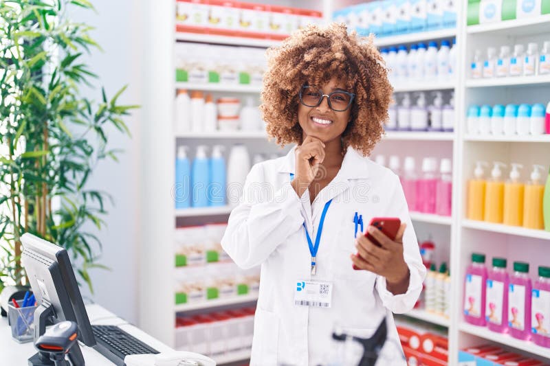 African American Woman Pharmacist Using Smartphone Working at Pharmacy ...