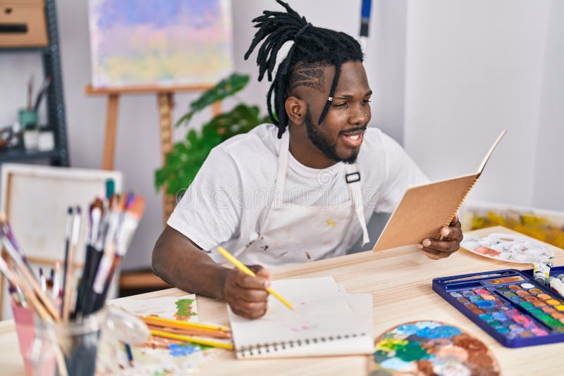 African American Woman Reading Book Drawing on Notebook at Art Studio ...